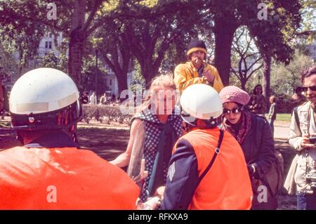 Young female protester in hippie attire with arms crossed lies on ...