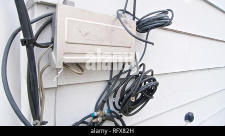 A telecommunications box installed and attached to the siding of a ...