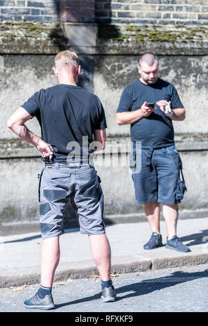 Two serious security guards looking at computer screen in control room ...