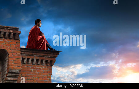 Thoughtful man in cape sitting on top of building. Mixed media Stock ...