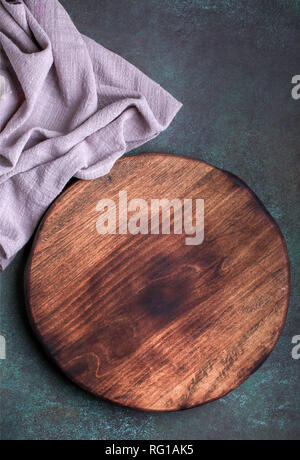 Empty round cutting board on a wooden table. Space for text. Top view ...