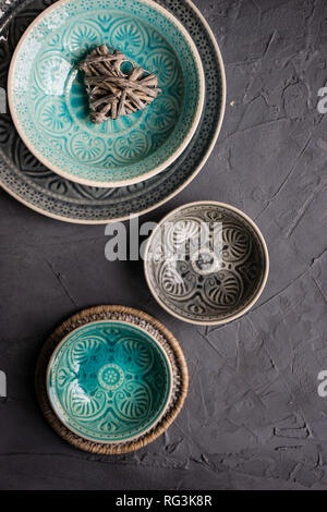 Table set with different size eastern style plates on concrete ...