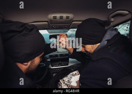 After the successful bank robbery, the thieves are sitting in the car ...