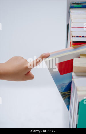 Child choosing book from bookshelf Stock Photo - Alamy