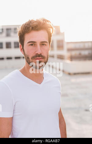 Waist up portrait of bearded young man setting up printing machine in ...