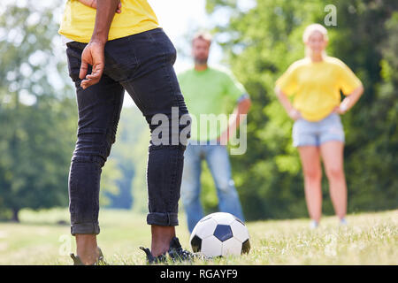 Young people play football on the green grass Stock Photo - Alamy