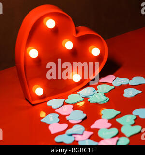 Glowing red heart with flashlights on the red background closeup Stock ...