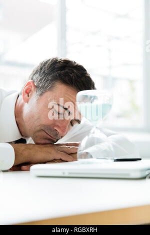 Businessman sleeping at office table on laptop computer Stock Photo - Alamy