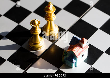 Small house with chess pieces Stock Photo - Alamy