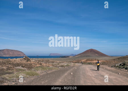 Cyclist on an unpaved track of the smallest Canary Island La Graciosa ...
