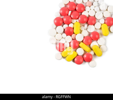 A handful of pills, capsules and multi-colored tablets on a plate next ...