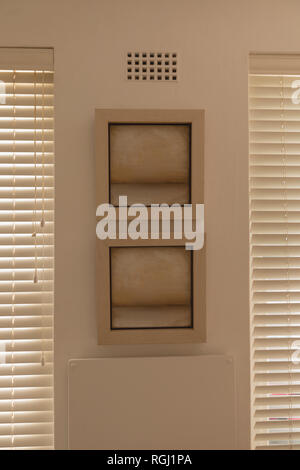 Blank frame on a wall between two glass doors of a wooden floor meeting ...