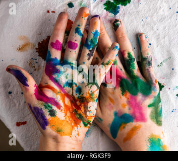 Messy pink, green, and red paint scattered on a white surface with copy ...