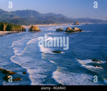 Waves and sea stacks near Chapman Point and distant town of Cannon ...
