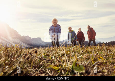Italy, South Tyrol, Geissler group, family hiking, sitting on meadow ...
