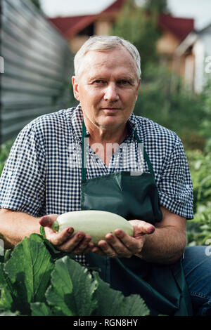 MAN HOLDING COURGETTES OR ZUCCHINI Stock Photo - Alamy