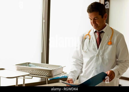 Doctor reading patient files Stock Photo - Alamy