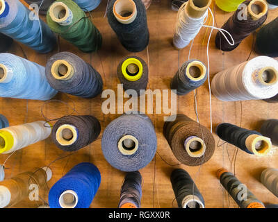 Reels with multi colored sewing threads pink background Stock Photo - Alamy