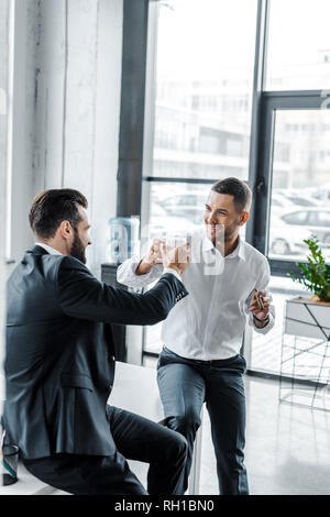 cheerful businessmen toasting with glasses of whiskey Stock Photo - Alamy