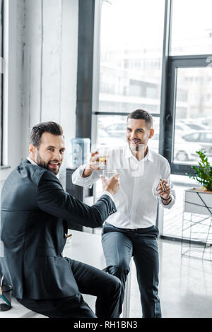 cheerful businessmen toasting with glasses of whiskey Stock Photo - Alamy