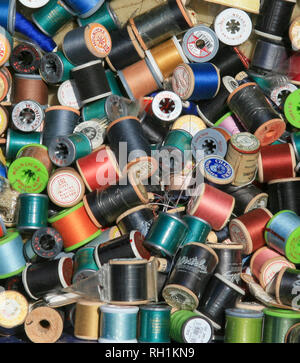 Sewing cotton in different colors, packed and unpacked, in plastic box ...