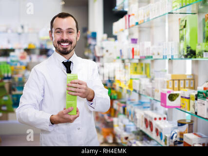Cheerful male pharmacist offering reliable medicine in pharmacy Stock ...