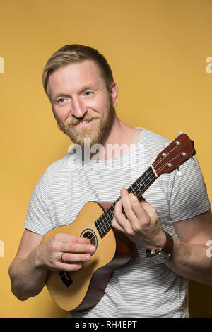 Portrait smiling man playing ukulele Stock Photo - Alamy