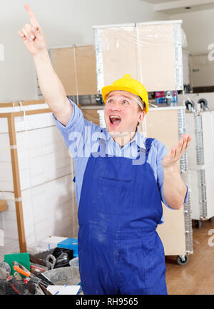 Puzzled builder handyman examining room while planning renovation works ...