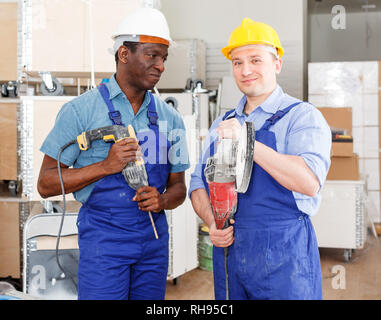 Professional builders using manual power tools during renovation work ...