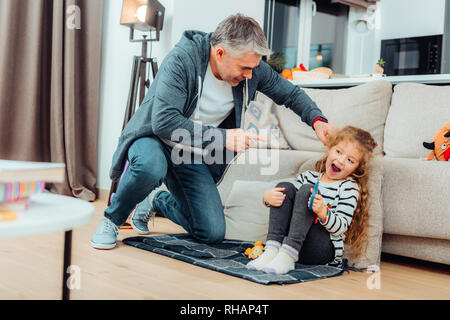 Scared child in red sweater looking away and covering head isolated on ...