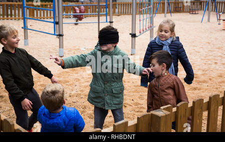 Happy kids playing blind man bluff Stock Photo - Alamy
