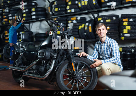 man customer holding his motorcycle at maintenance point Stock Photo ...