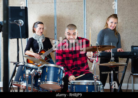 Expressive cheerful positive smiling drummer with his bandmates ...