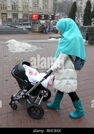 Muslim woman, pushing stroller; wearing burqa; little boy; ethnic; face ...