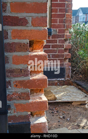 Extending a brick wall by toothing out or using interlocking bricks ...