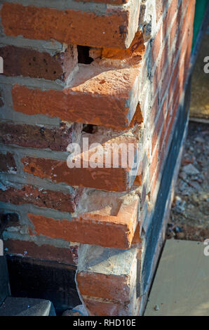 Extending a brick wall by toothing out or using interlocking bricks ...