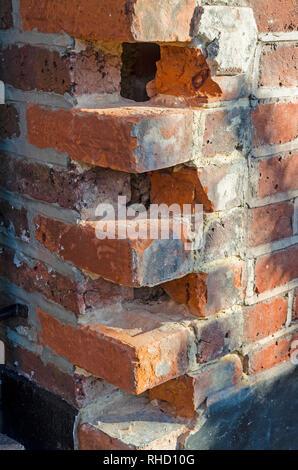 Extending a brick wall by toothing out or using interlocking bricks ...