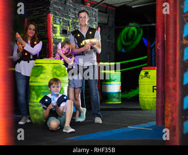 Portrait of happy kids and theirs parents with laser guns during ...