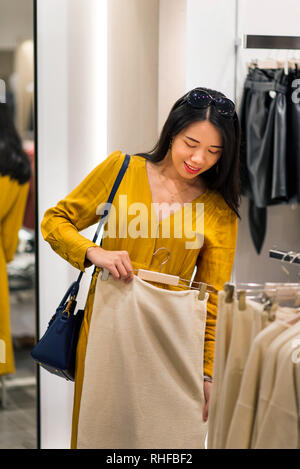 Woman choosing new skirt in shop Stock Photo - Alamy