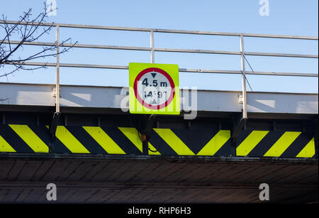 Low railway bridge with black and yellow markings Stock Photo - Alamy