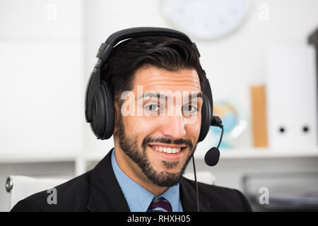 Portrait of spanish man dispatcher who is talking with client in office ...