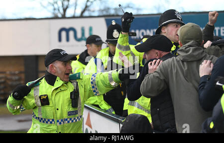 British police officer with batons drawn policing football match during ...