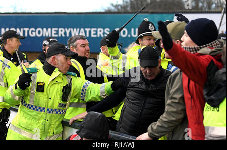 British police officer with batons drawn policing football match during ...