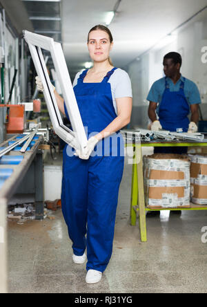 Female master is working with window frame in the window workshop Stock ...