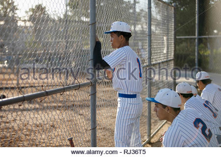 People watching a high school baseball game from behind a fence Stock ...