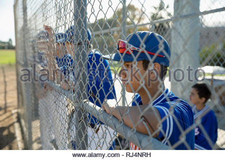 People watching a high school baseball game from behind a fence Stock ...