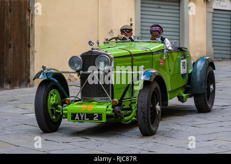 A vintage car, joining the rallye Mille Miglia, driving through the ...