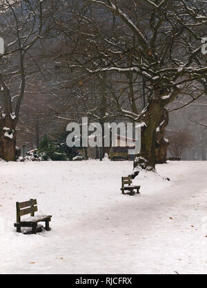 Snow covered Agios Nikolaos (Saint Nicholas) park with benches and path ...