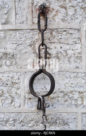 Old rusty shackles with chain on wall in prison Stock Photo: 241050469 ...