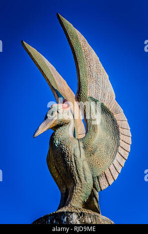 Totem poles topped by intricately carved wooden birds stand sentry in ...